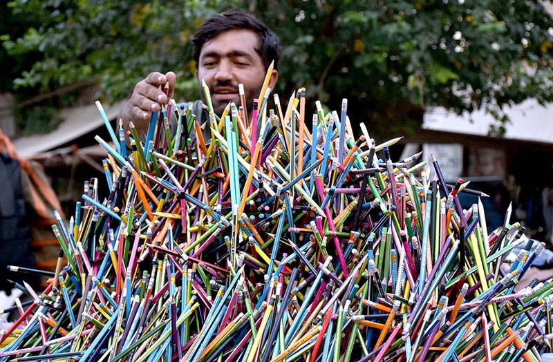 A vendor arranging and displaying the pencils to attract the customers ...