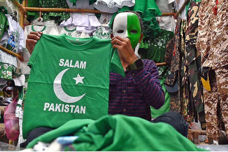 A vendor wear national flag colour face mask holds national flag for ...