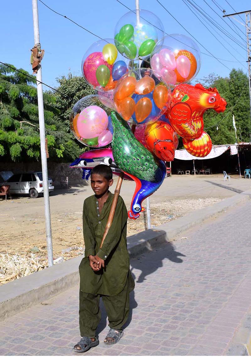 A young vendor selling balloons to attract the customers at Al Murtaza ...