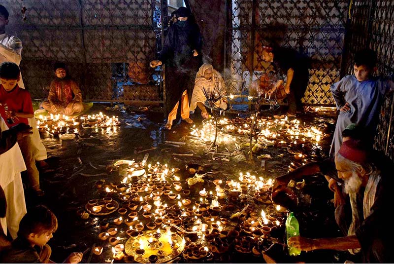 A devotee lits-up earth lamps at Data Darbar in connection with 980th ...
