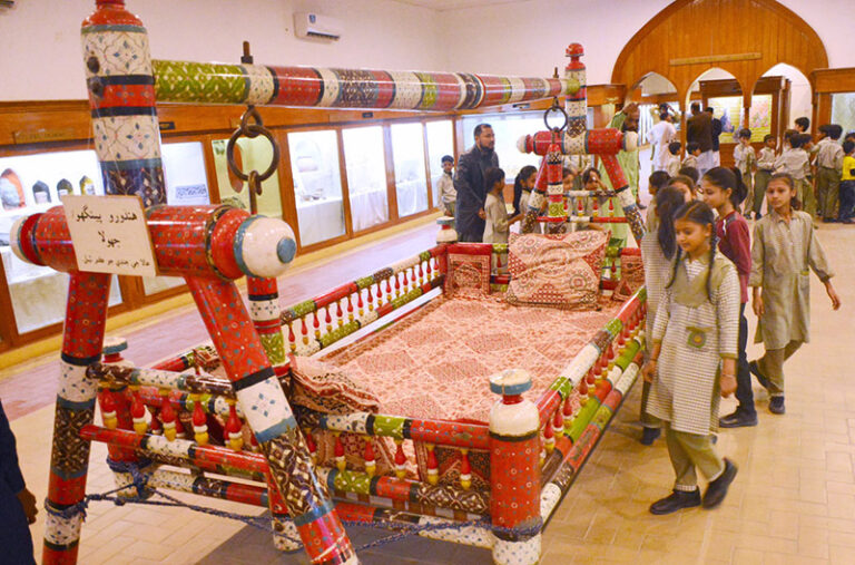 Children observing the Sindhi cultural swing model at the Shah Latif ...