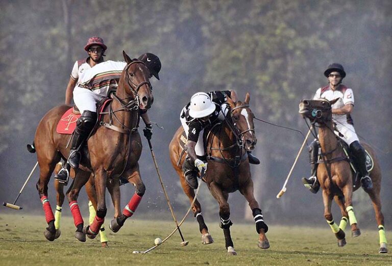 Players struggling to get hold on the ball during Polo match between ...