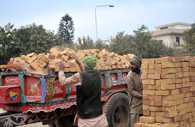 Labourers busy loading bricks on tractor trolley at f-11 Margala Road