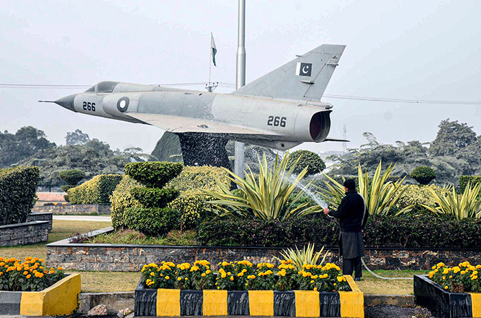PDA worker busy in watering plants at Hayatabad Jahaz Chowk.