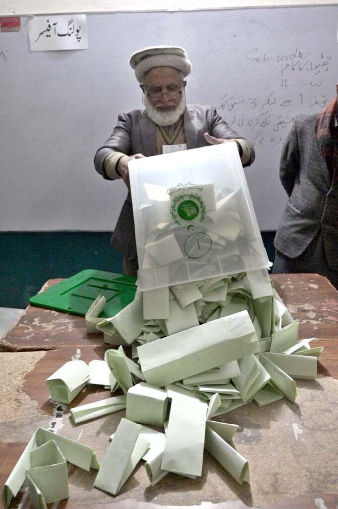 Election official opens ballot box to count votes after polls end ...