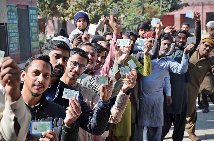 An elderly person shows his thumb after casting his vote at polling ...