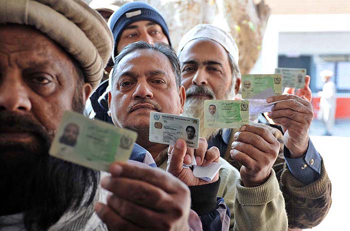 An elderly person shows his thumb after casting his vote at polling ...