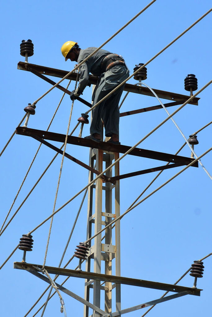 WAPDA worker busy in installed electricity cable on the electric pole ...