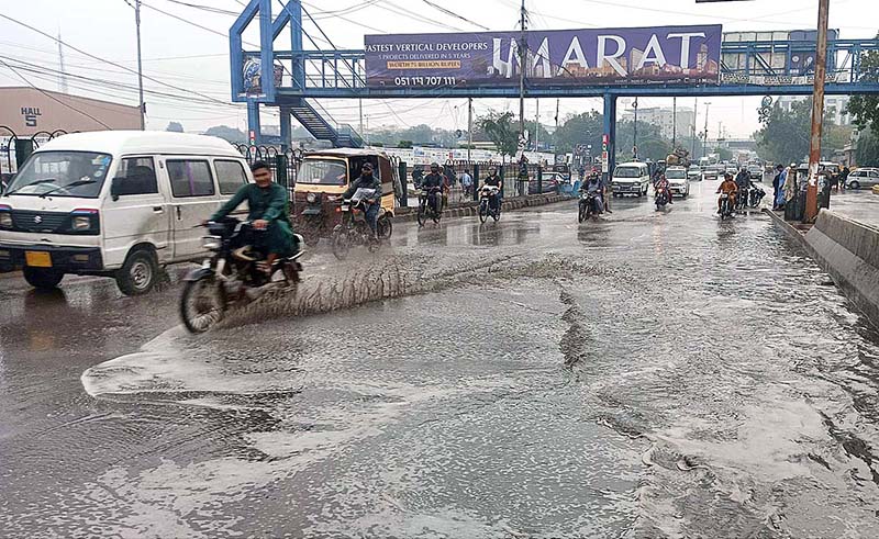 Vehicles passing through stagnant rain water accumulated on road in the ...