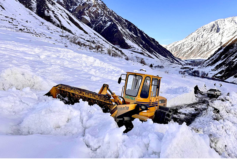 Heavy machineries being used to remove snow from the blocked road of ...