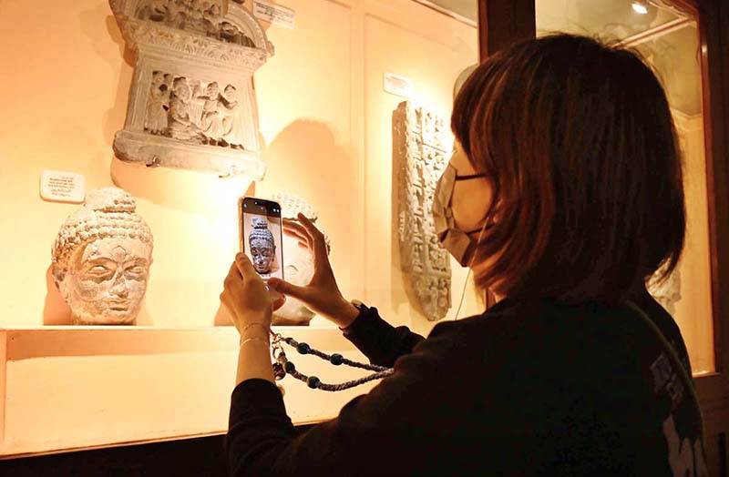 Chinese visitor taking pictures of displayed stuff with cell phone ...