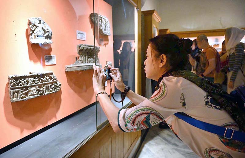 Chinese visitor taking pictures of displayed stuff with cell phone ...