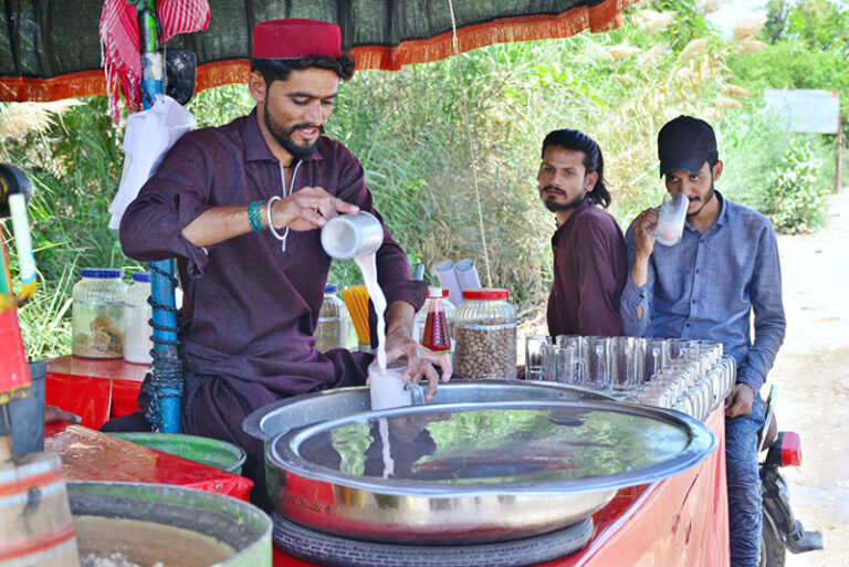 Vendor selling traditional drink Thadal to customers on the roadside ...