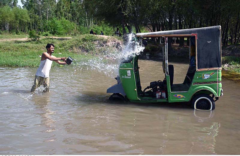 A person washing his rickshaw in a local stream at Charsadda Road.