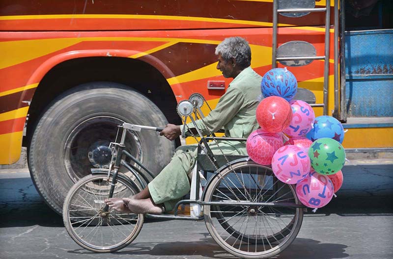 A disable vendor on the way on tricycle wheelchair selling balls to ...
