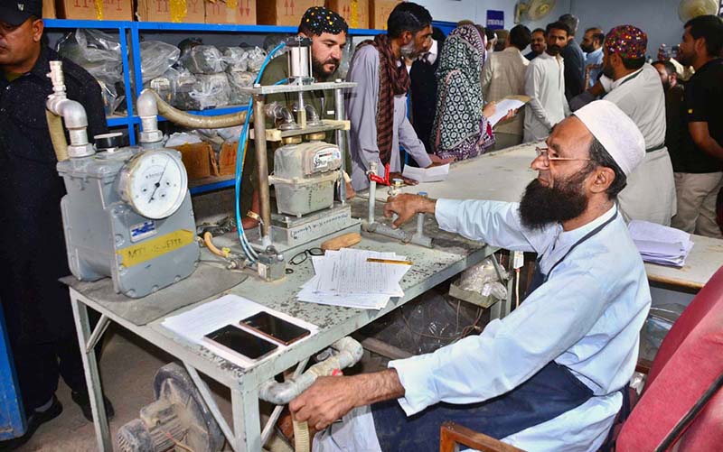 Gas employee checking gas meters at laboratory of Sui Southern Gas ...