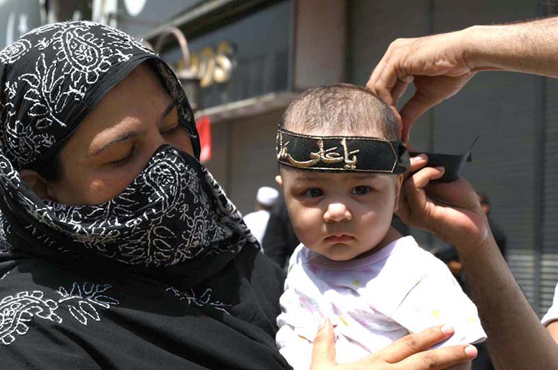 A woman with her child attending the 9th Muharram Zuljinah procession ...