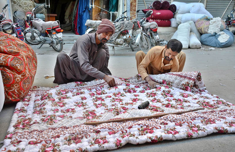 Workers diligently sewing traditional handmade quilts (polyester ...