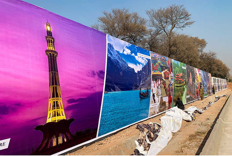 CDA workers paste posters along Srinagar Highway, presenting the beauty ...