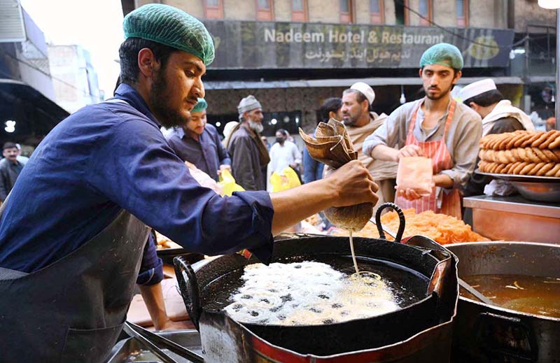 Worker busy in preparing traditional sweet item ‘Jalebi’ at Fawara ...