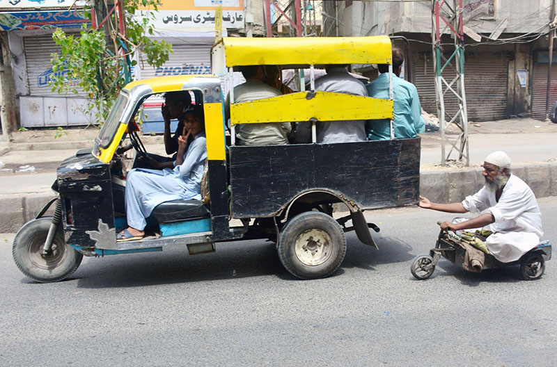A person with disabilities on wheelchair, holding tri-cycle rickshaw ...