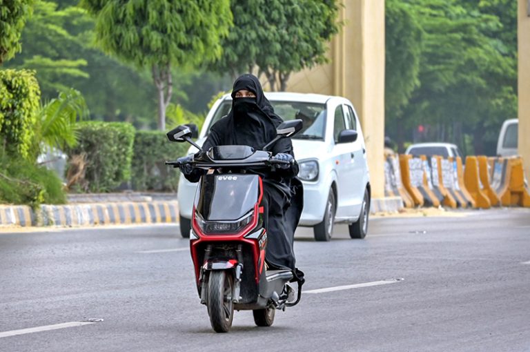 A woman rides a scooty on the way to her destination in the City