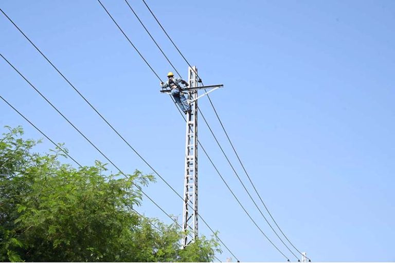 WAPDA workers busy in installing new electricity cables on electric ...