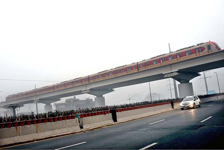 A beautiful view of the orange train on the way at Thokar Niaz Baig